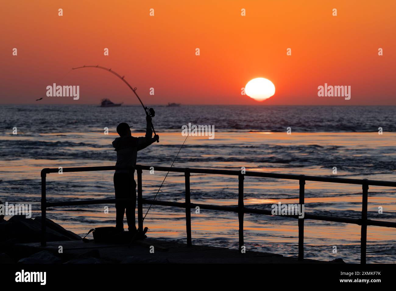 Lone fisherman at Indian River Inlet at sunrise, Delaware Seashore ...