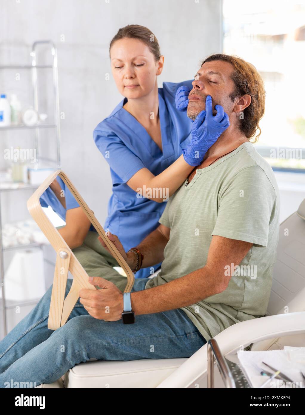 Adult female doctor examining face of male patient Stock Photo - Alamy