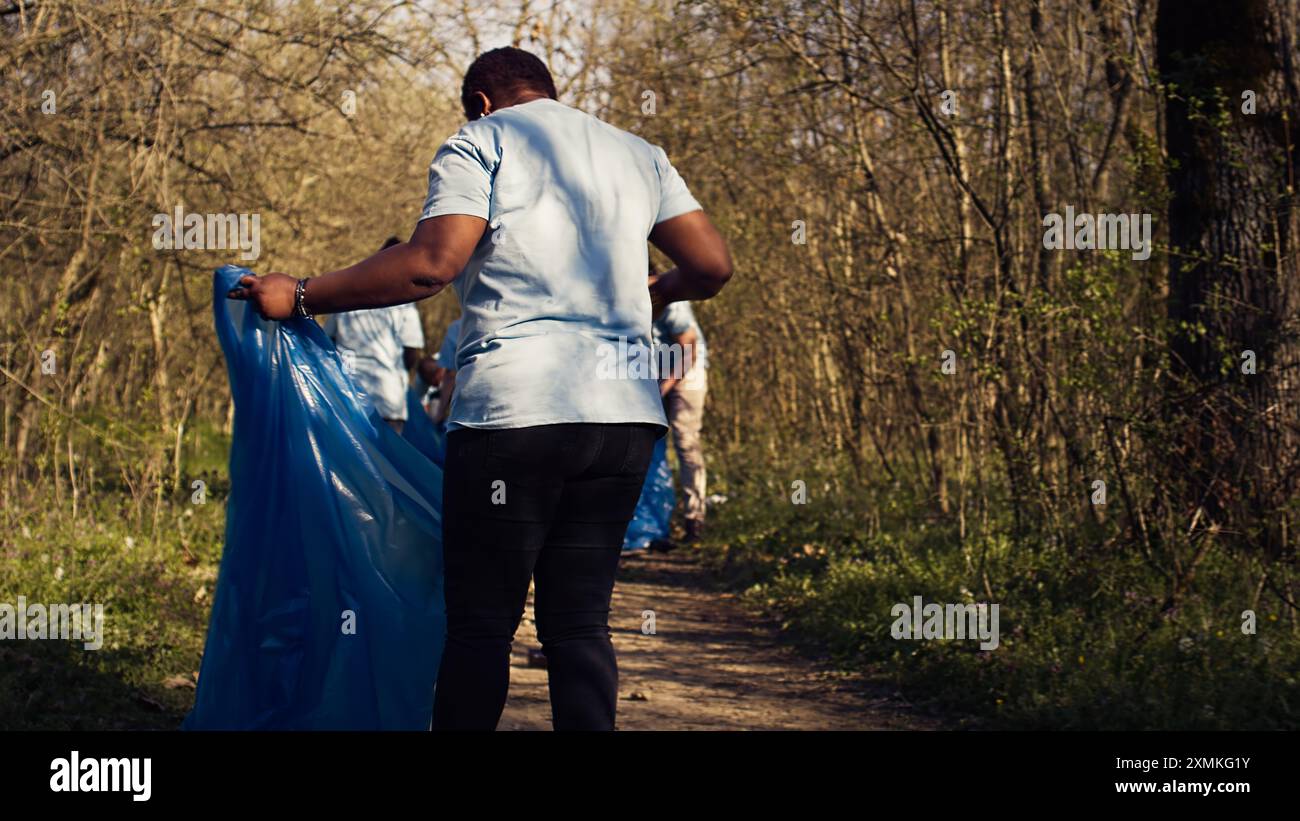Diverse activists group using claw tools to grab trash and plastic ...