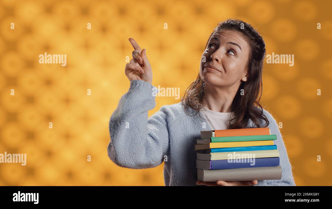 Portrait of smiling woman pointing towards empty copy spaces while ...