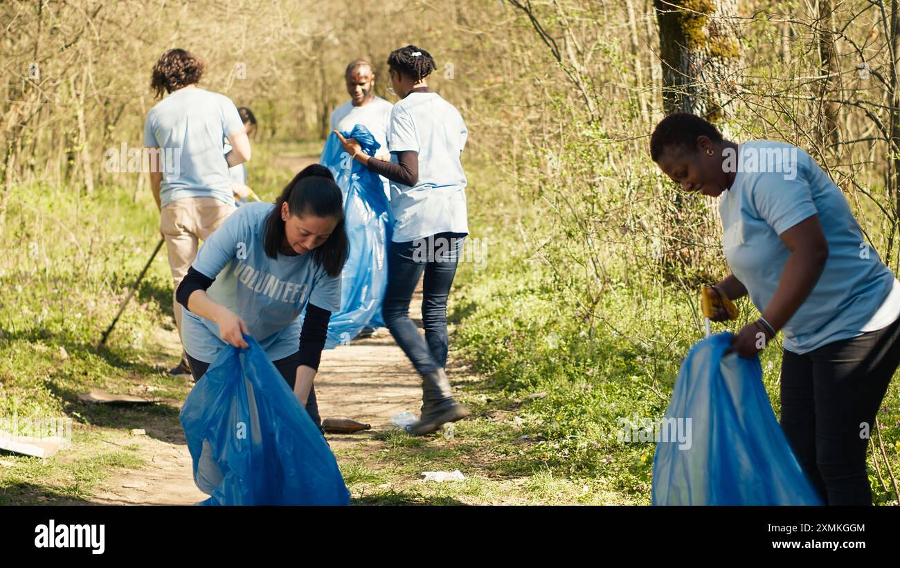 Group of diverse volunteers collecting rubbish from the woods and ...