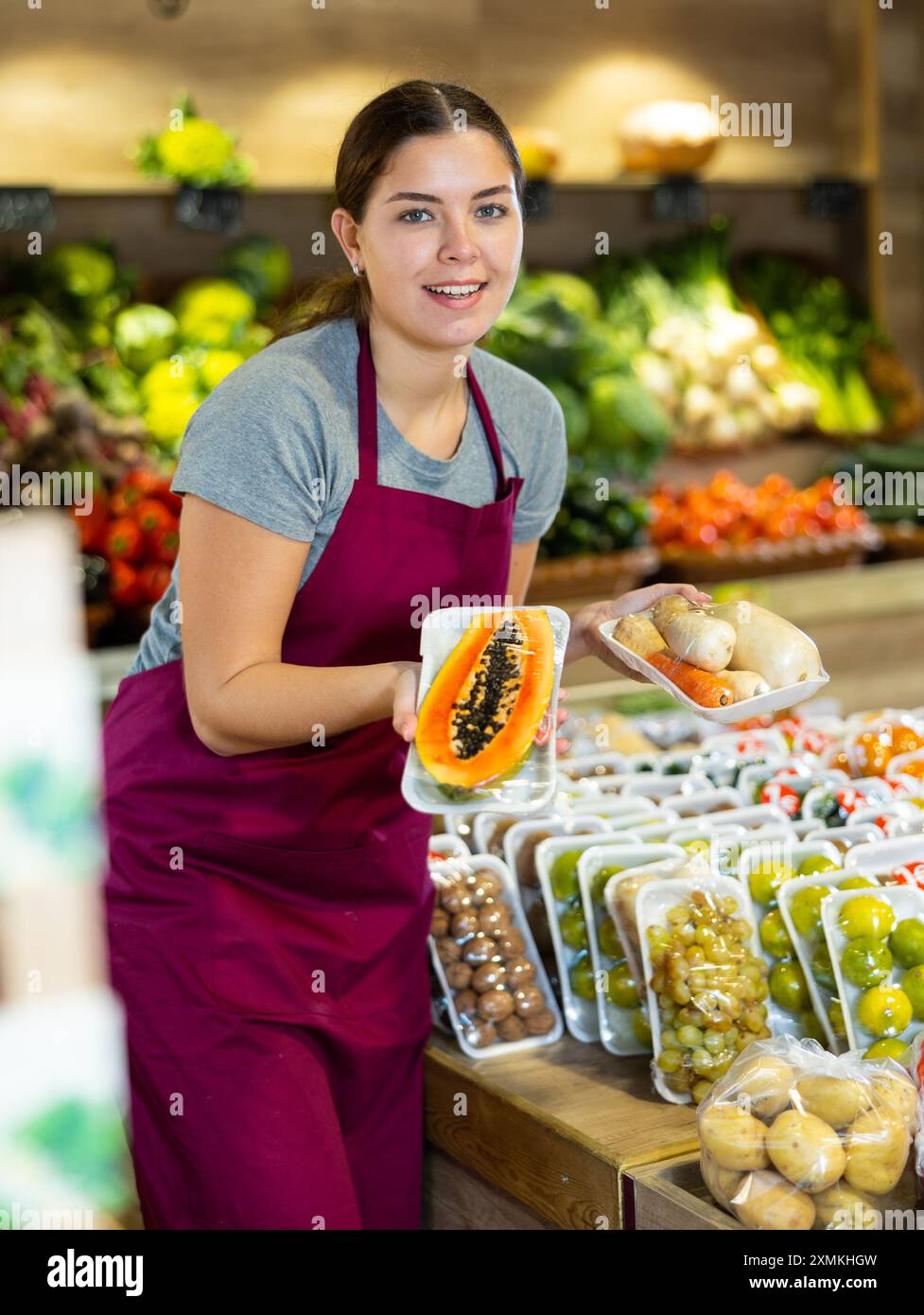 Female worker offers various packaged fruits and vegetables Stock Photo ...