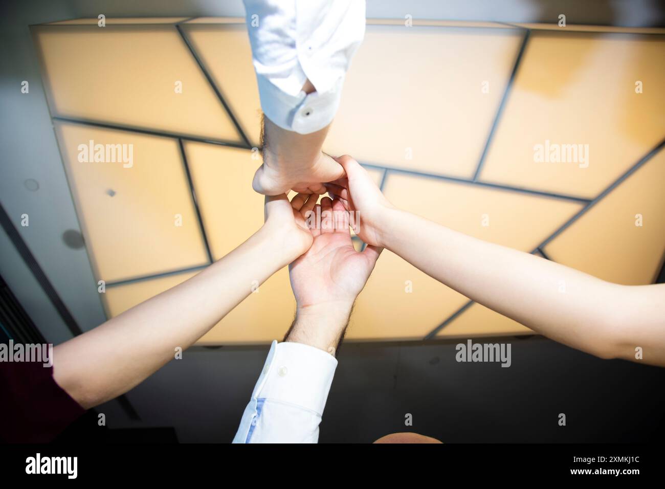 Three people are holding hands in a circle, symbolizing unity and ...