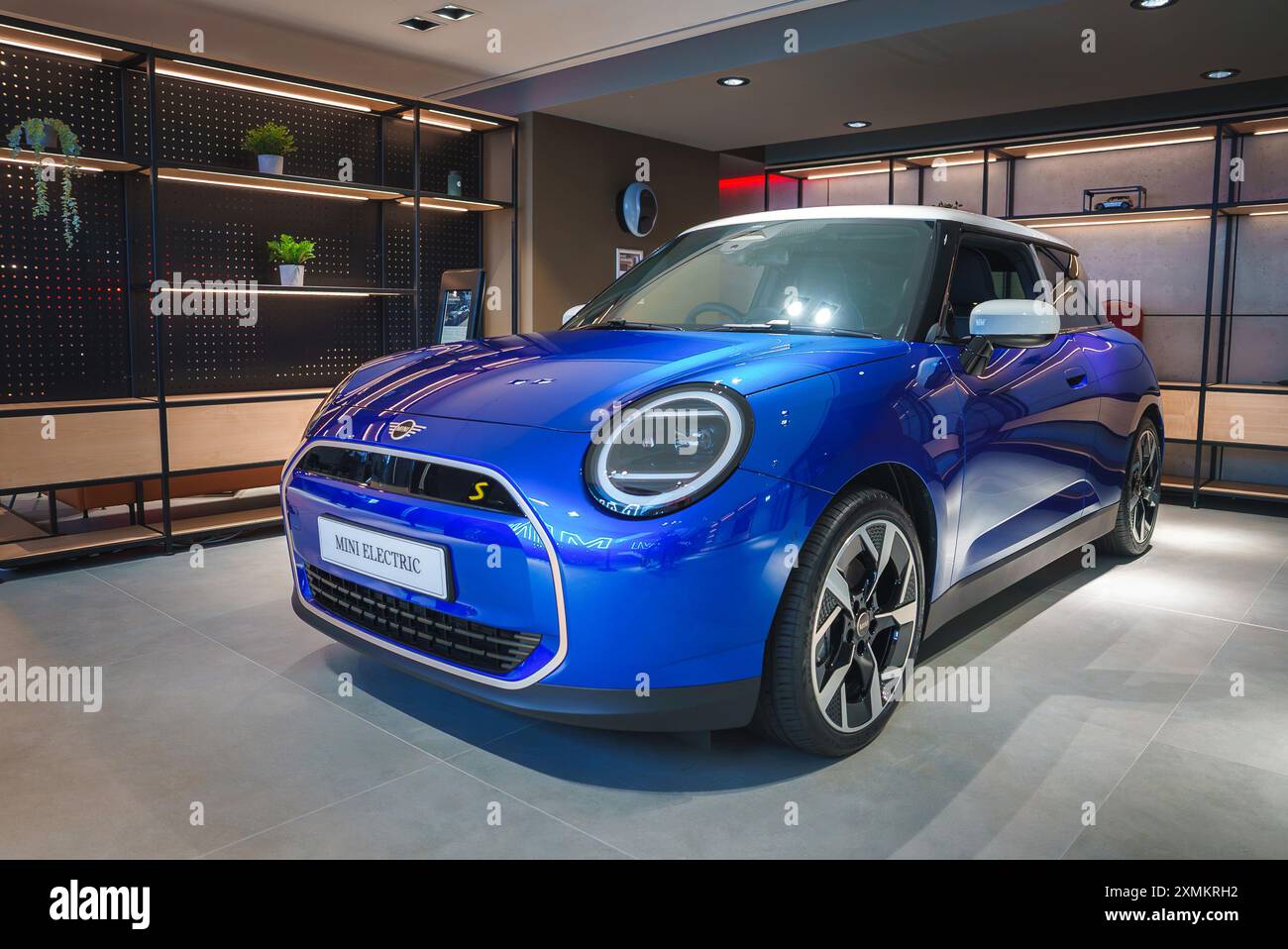 Blue Mini Electric Car in Modern Showroom with Sleek Shelving Units ...