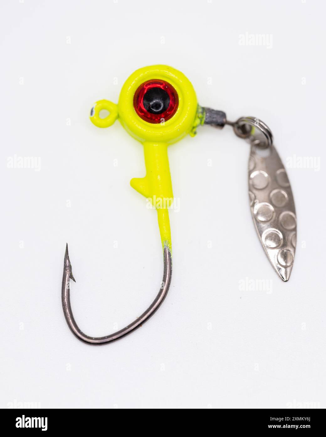 Chartreuse fishing jig lure with a fake eye and a silver spoon on white ...