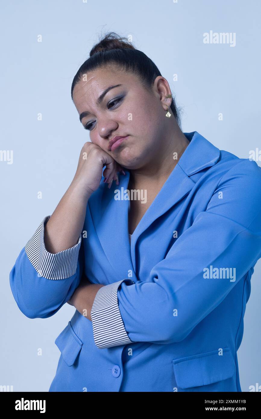 A thoughtful woman poses gracefully in a stylish blue suit, which ...