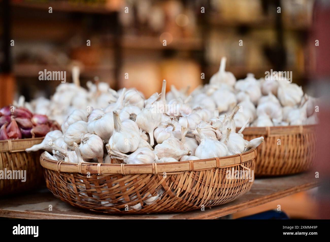 Daylight photo of garlic and shallots displayed in a bamboo basket ...