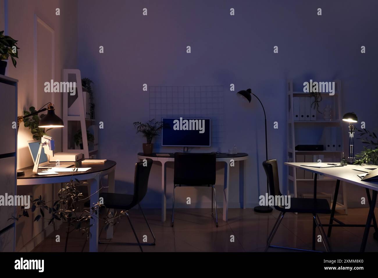 Interior of dark office with desks, plants and glowing lamps Stock ...