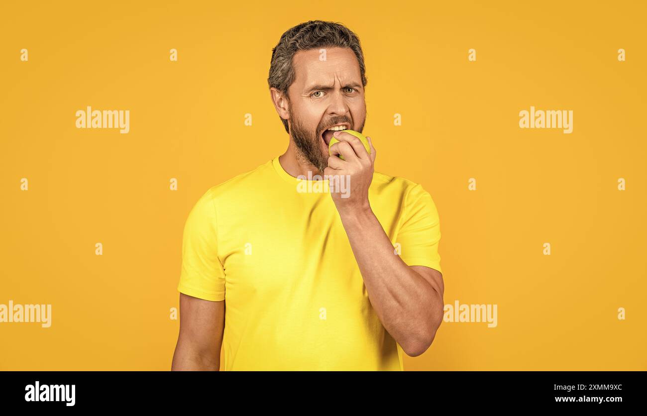 healthy man bite vitamin fruit in studio. photo of healthy man with ...