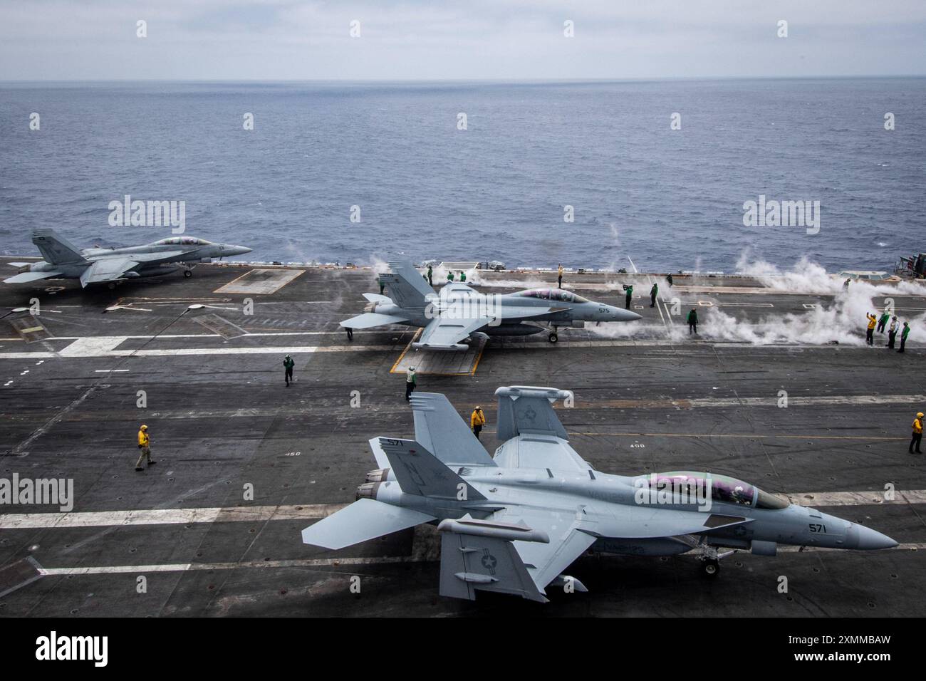 Sailors prepare aircraft for flight operations on the flight deck of ...