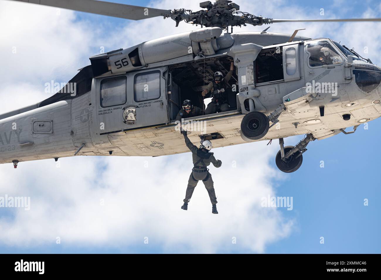 U.S. Naval Aircrewman 2nd Class Brenden Spicer is lowered by a hoist ...