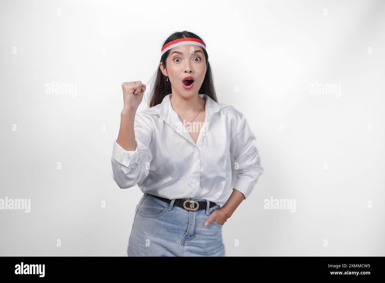 Excited young Asian woman wearing country flag headband and clenching ...