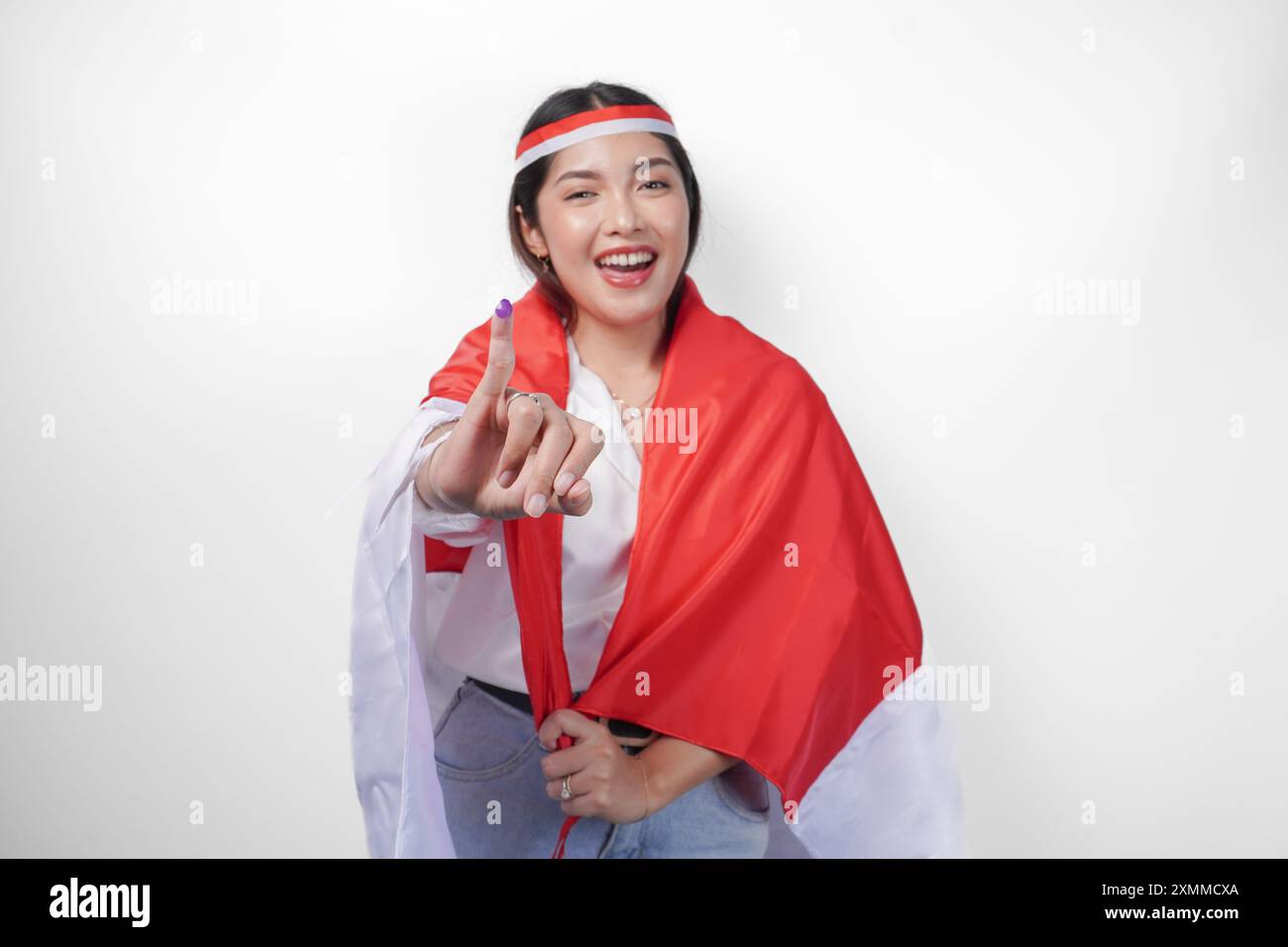 Excited Indonesian woman proudly showing little finger dipped in purple ...