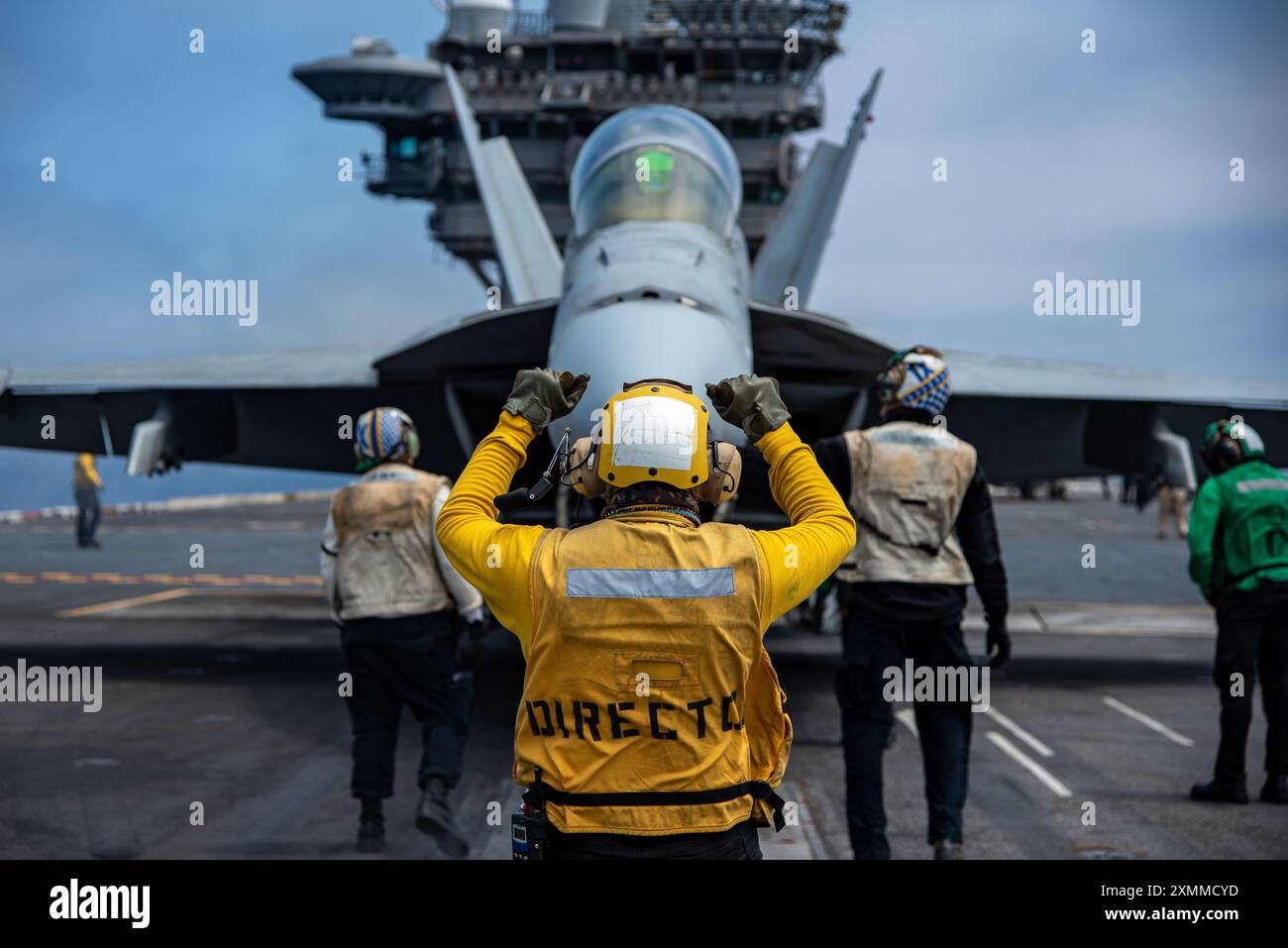 A Sailor directs an F/A-18F Super Hornet from the "Flying Eagles" of Strike Fighter Squadron ...