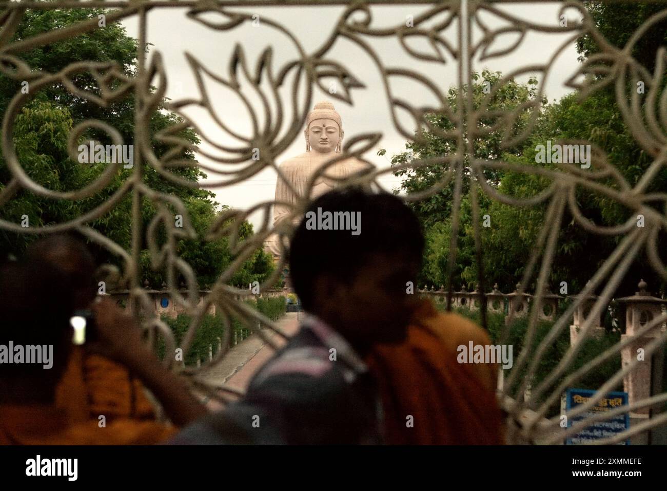 Monks pays attention to a 64-feet-high Great Buddha statue from behind ...
