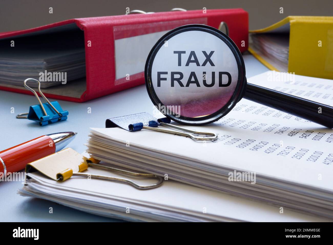 Tax fraud concept. Financial statement papers and a magnifying glass ...