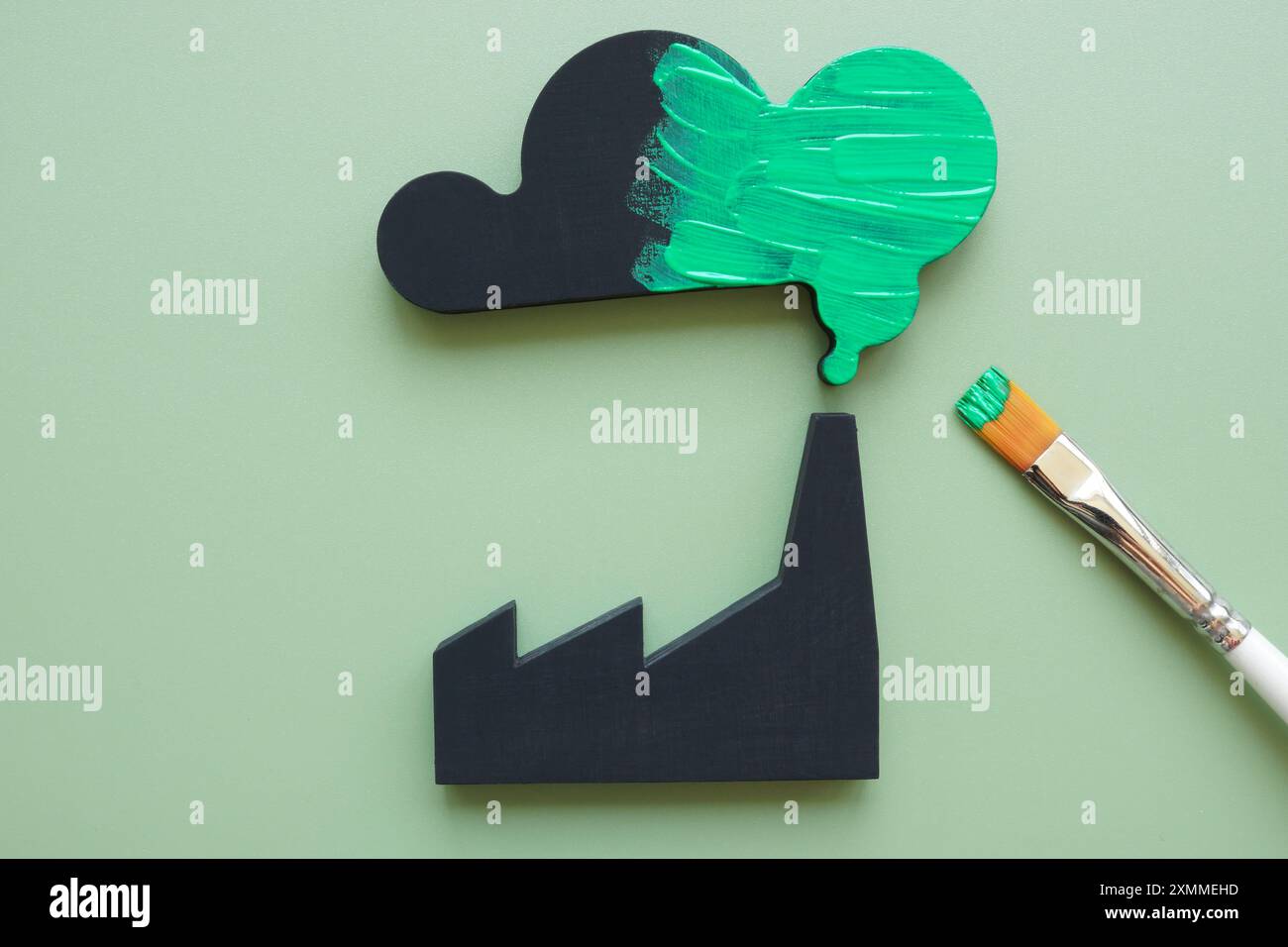 Sustainable manufacturing concept. Factory model, brush and green paint ...