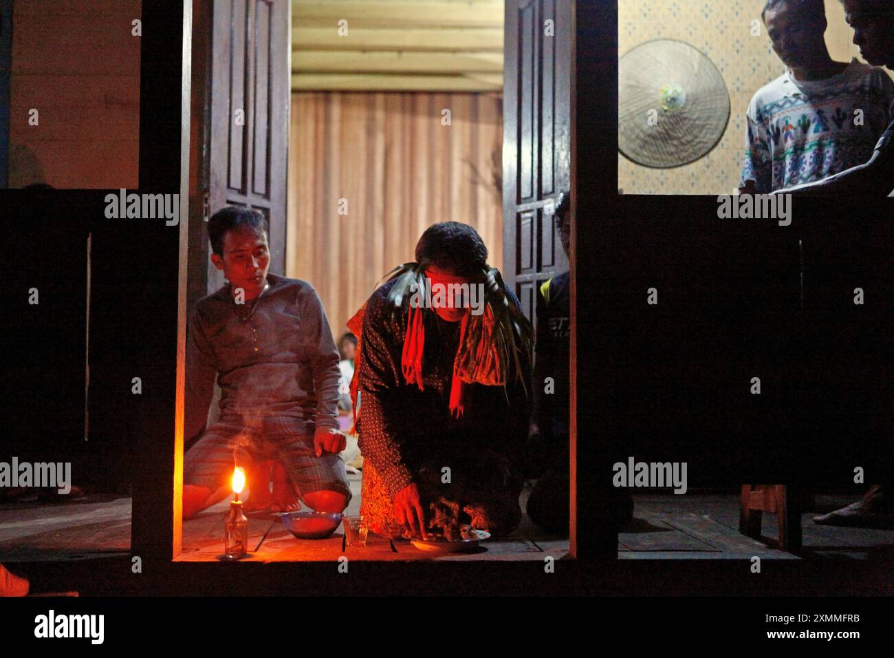 A witch doctor conducting a ritual on the porch of Dayak Iban's ...