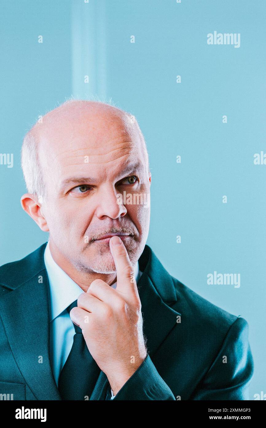 Mature businessman in a suit, thinking deeply in his office, showing ...