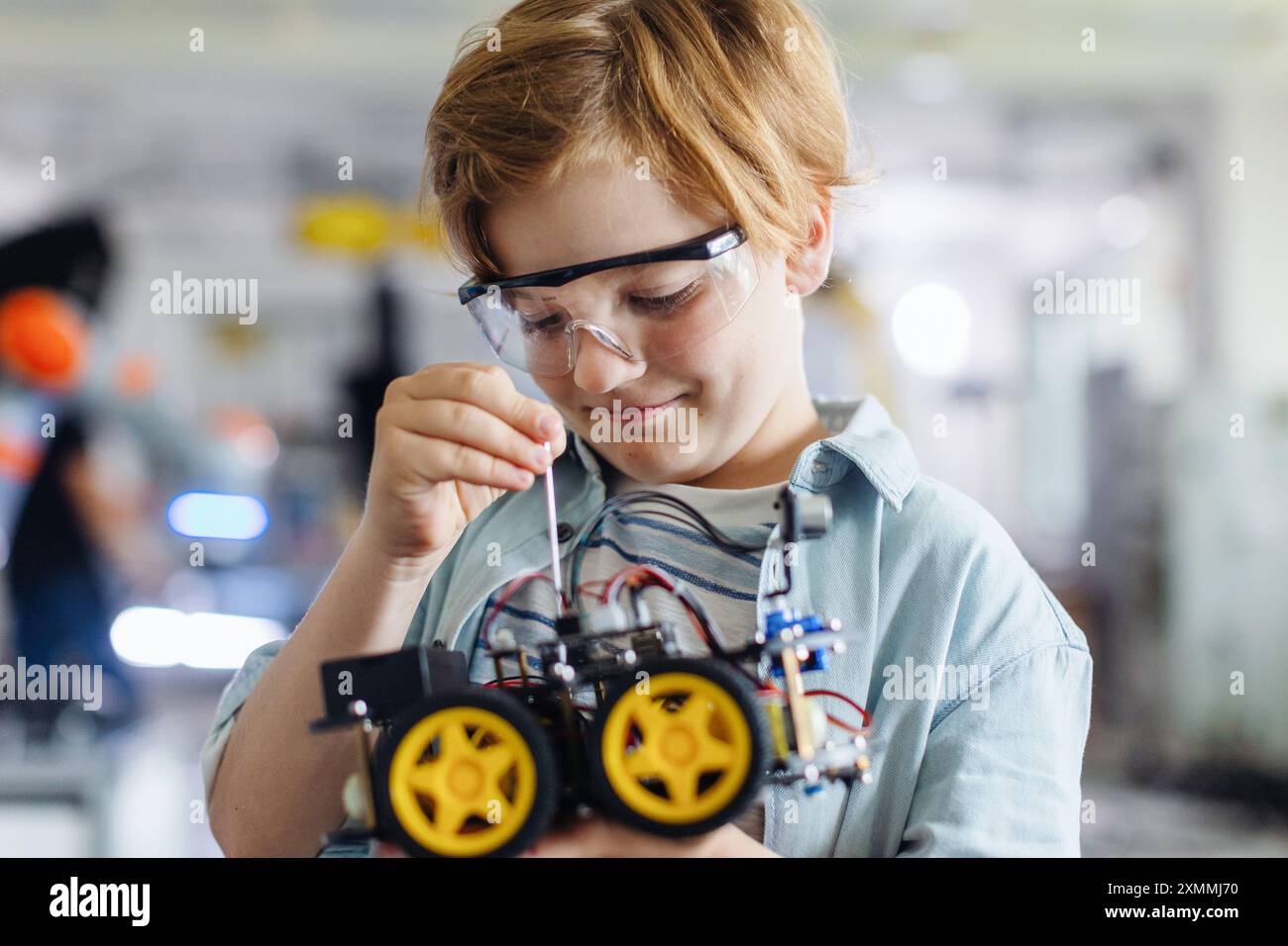 Portrait of schoolboy building robotic car in after-school robotics ...