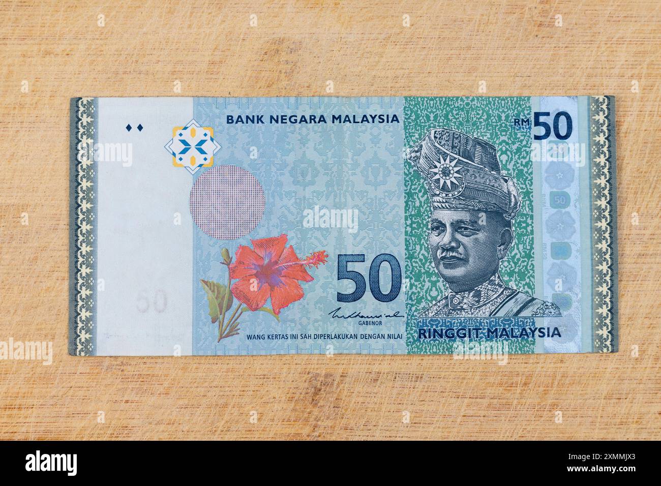 The blue and green coloured Malaysian 50 ringgit banknote on a wooden ...