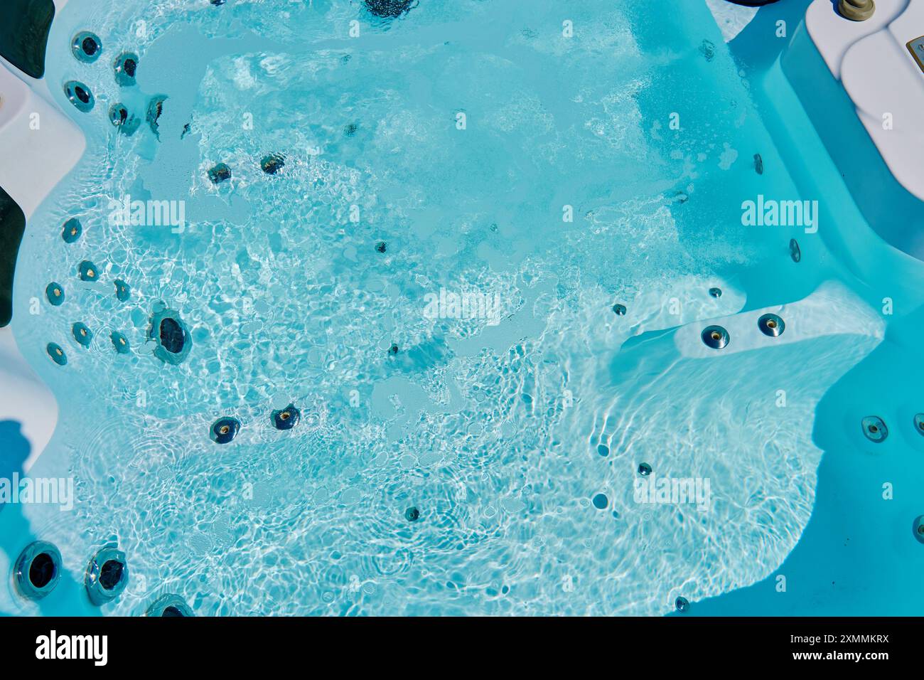 Close-up shot bubbling water in hot tub with headrests. Blue water in ...