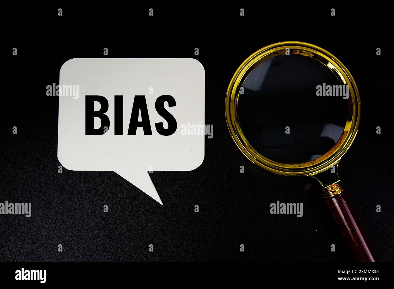 Bias text on speech bluble with magnifying glass top view on blck ...