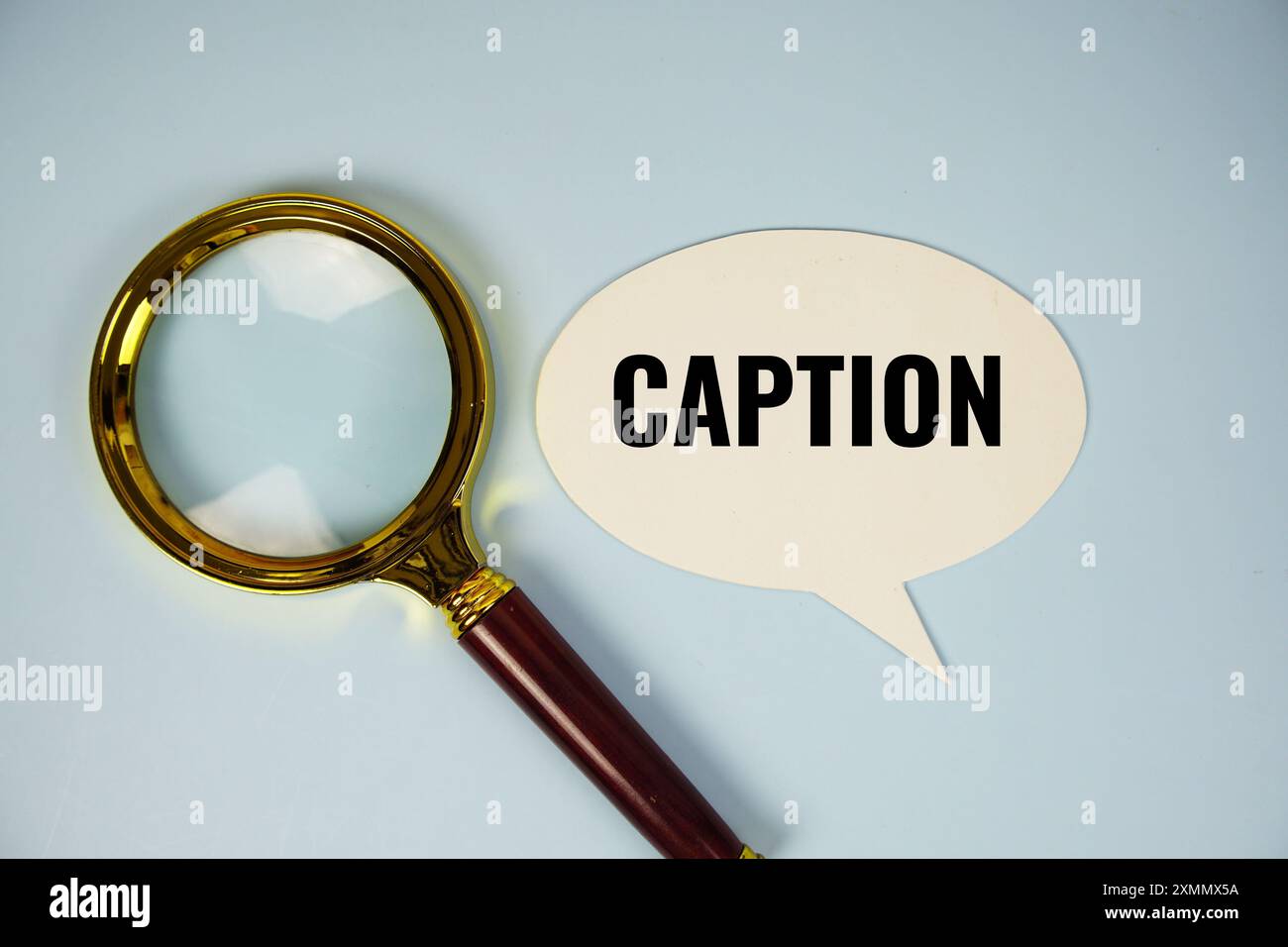Caption text on speech bluble with magnifying glass top view on blue ...