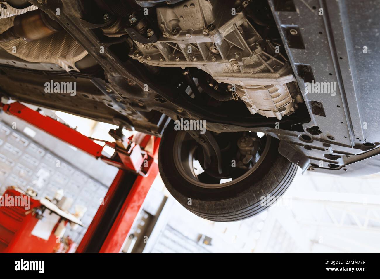 View of a car's underbody on a lift in a repair shop, showcasing ...