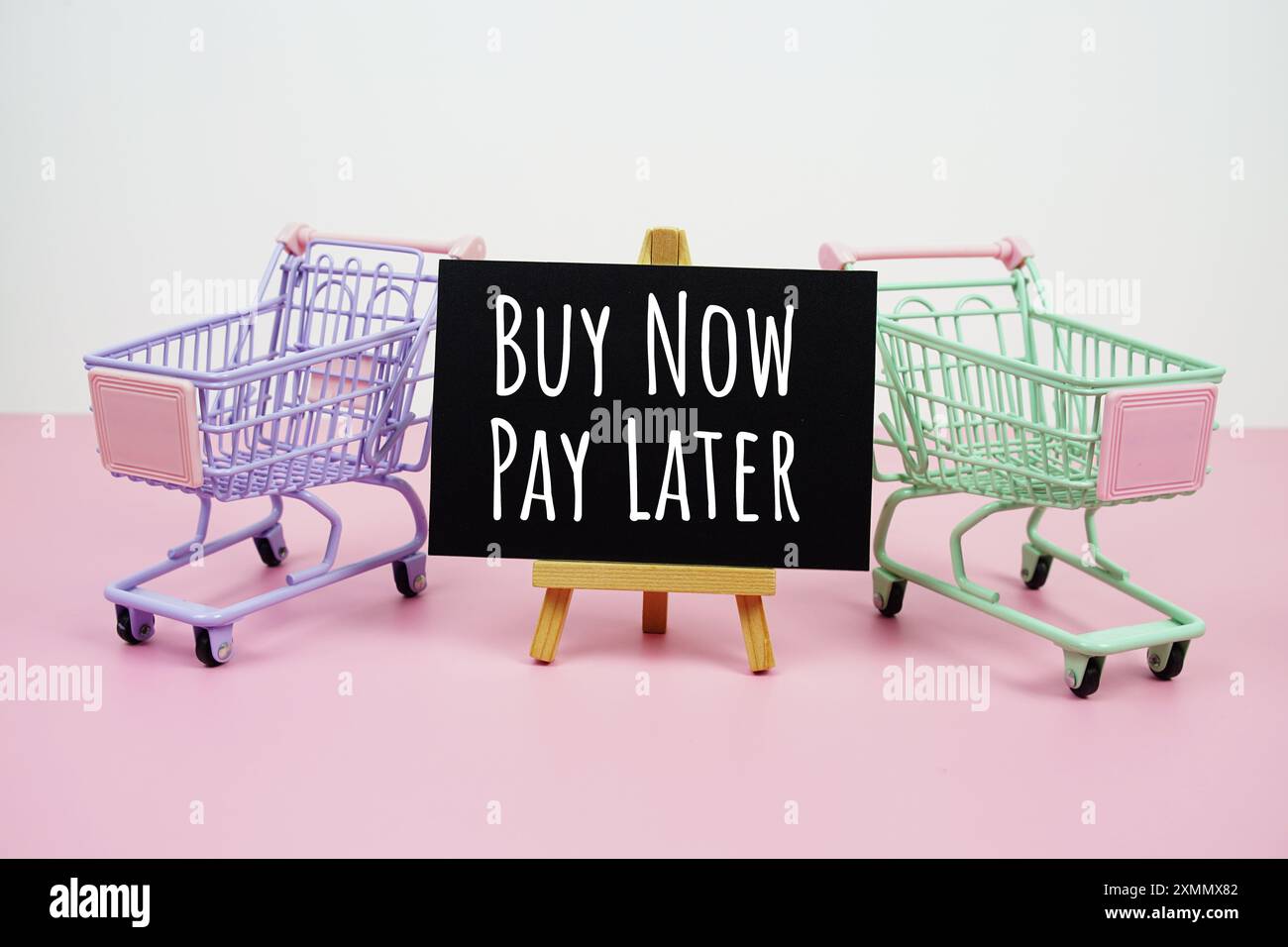 Buy Now Pay Later text message and trolley shopping cart on pink ...