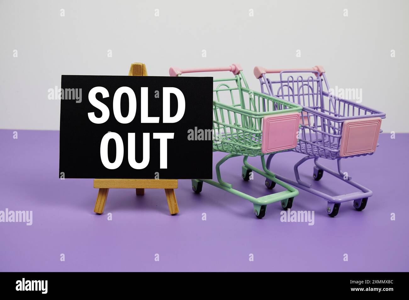 Sold Out text message and trolley shopping cart on purple background ...