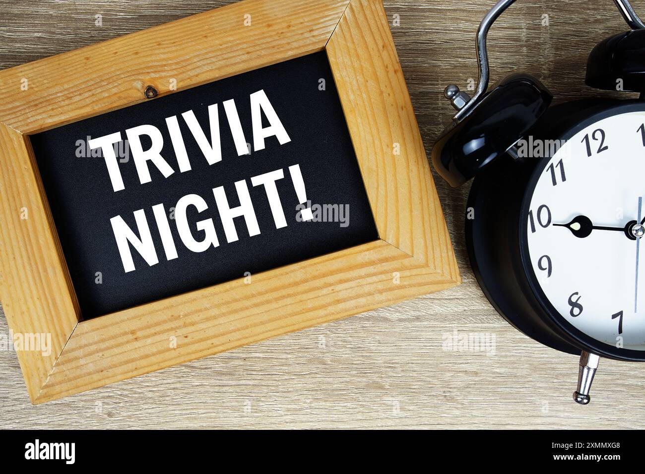 Trivia Night text on chalkboard with alarm clock top view on wooden ...