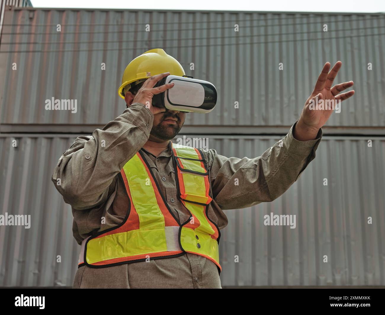 Engineer wearing an augmented reality headset and using gestures to control objects in augmented ...