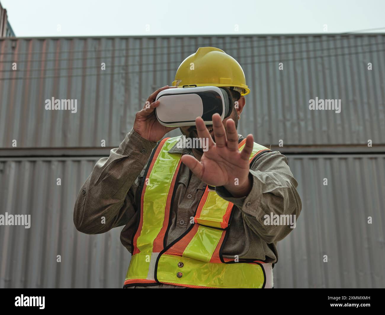 Engineer wearing an augmented reality headset and using gestures to control objects in augmented ...