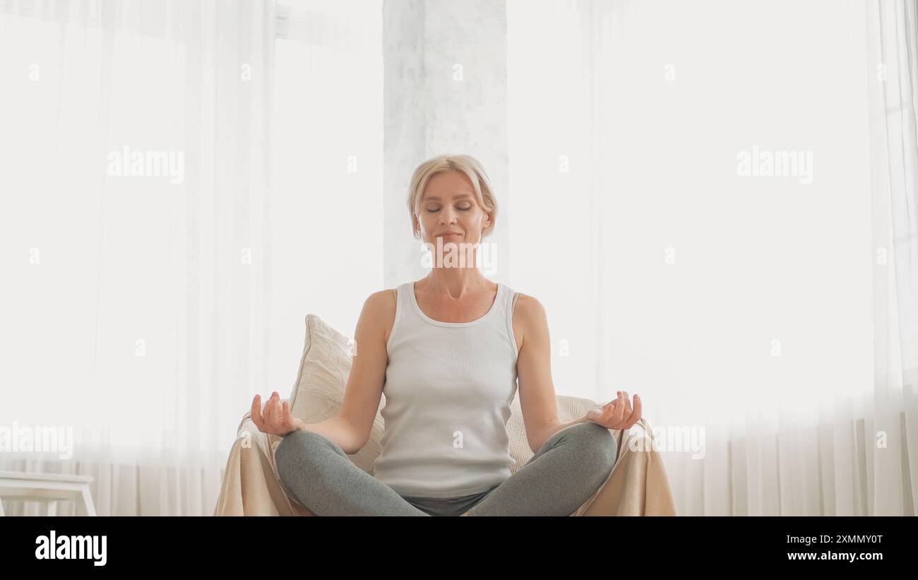 Meditation wellbeing. Domestic practice. Calm woman sitting in yoga ...