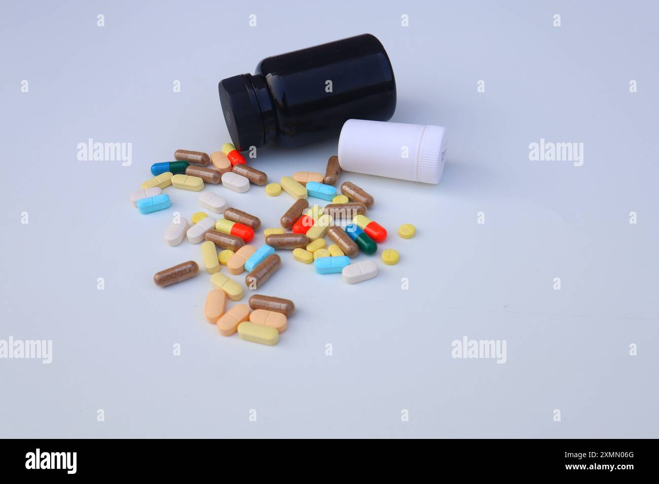Assorted medicine tablets, capsules and caplets scattered next to black ...