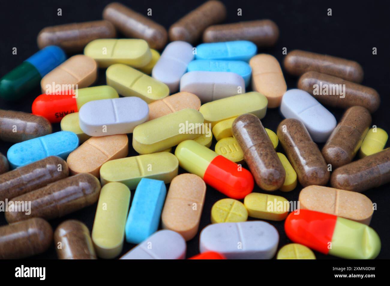 Various kinds of medicine tablets, capsules and caplets mixed in close ...
