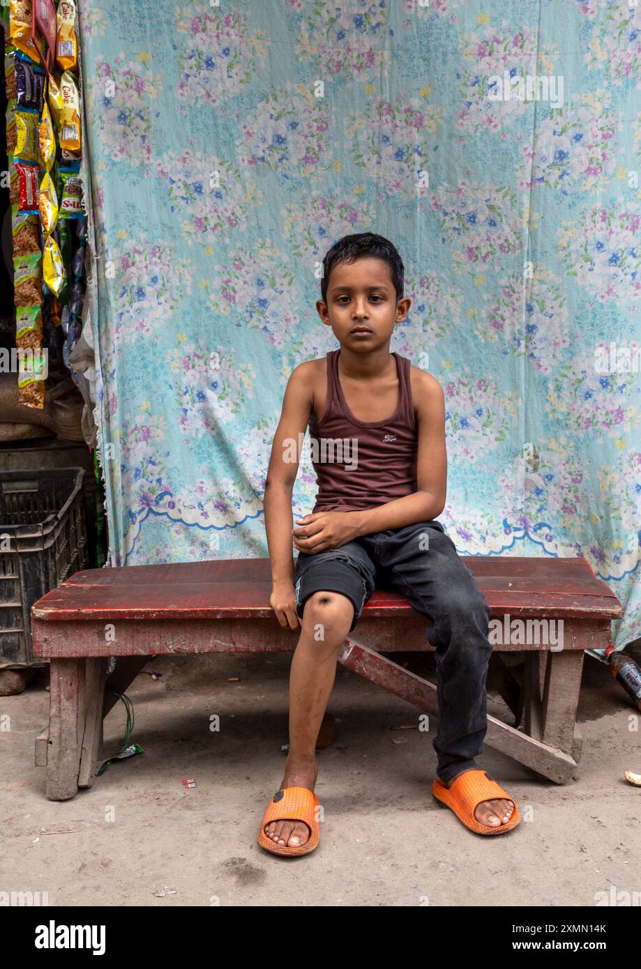 Bangladeshi boy sit on a bench in Korail slum, Dhaka Division, Dhaka ...