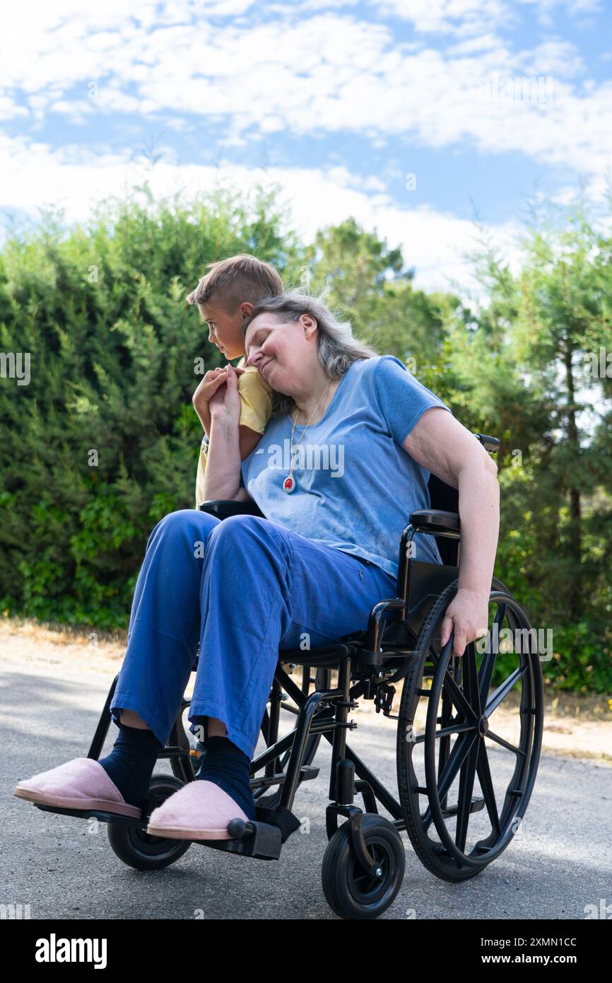 Grandmother in a wheelchair giving her grandson a pamper outdoors Stock ...