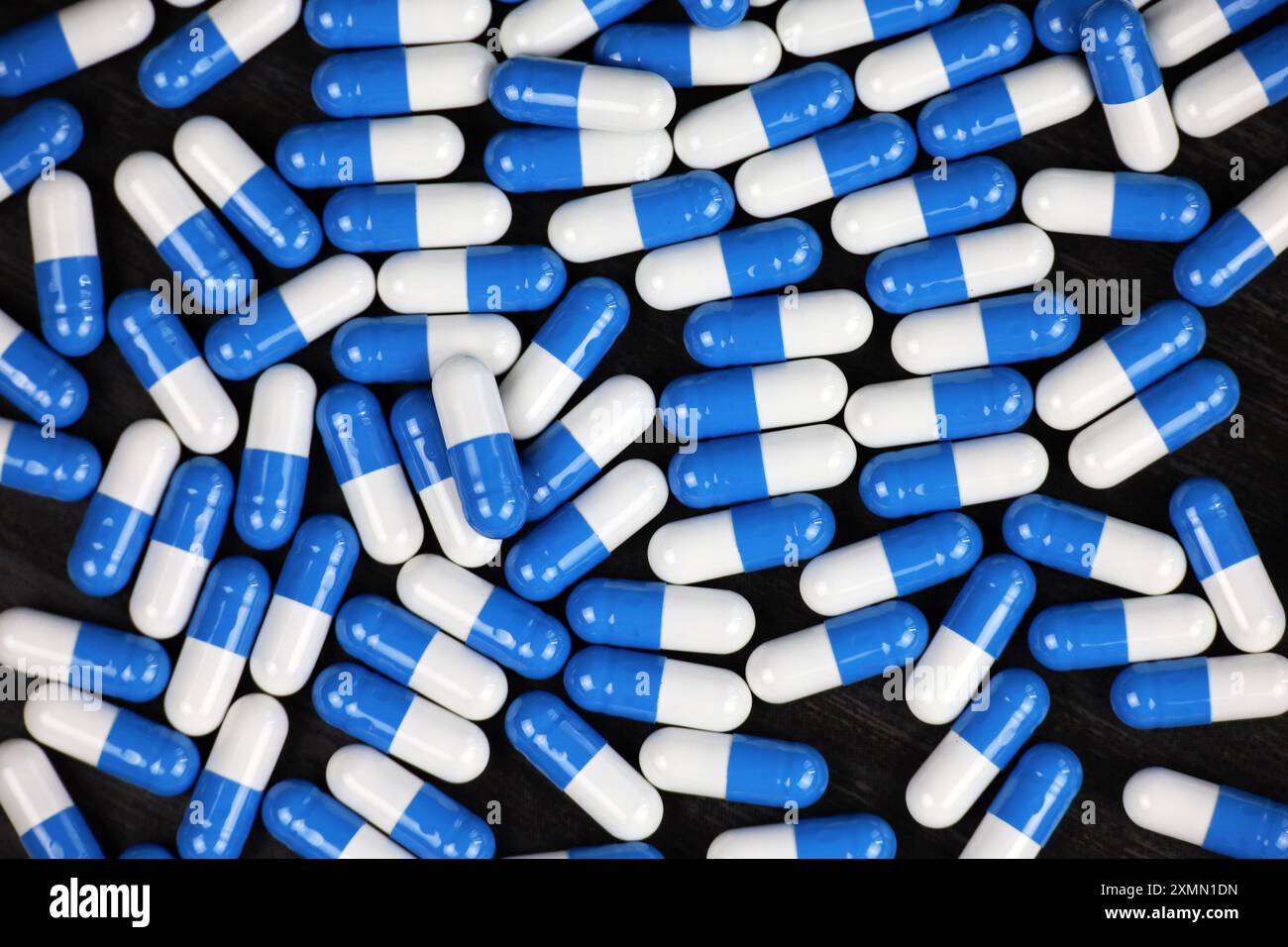 Blue white pills, variation of scattered medication in capsules ...