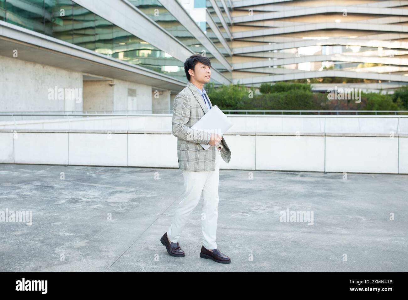 Man Walking Outside Modern Building With Documents in Hand Stock Photo ...