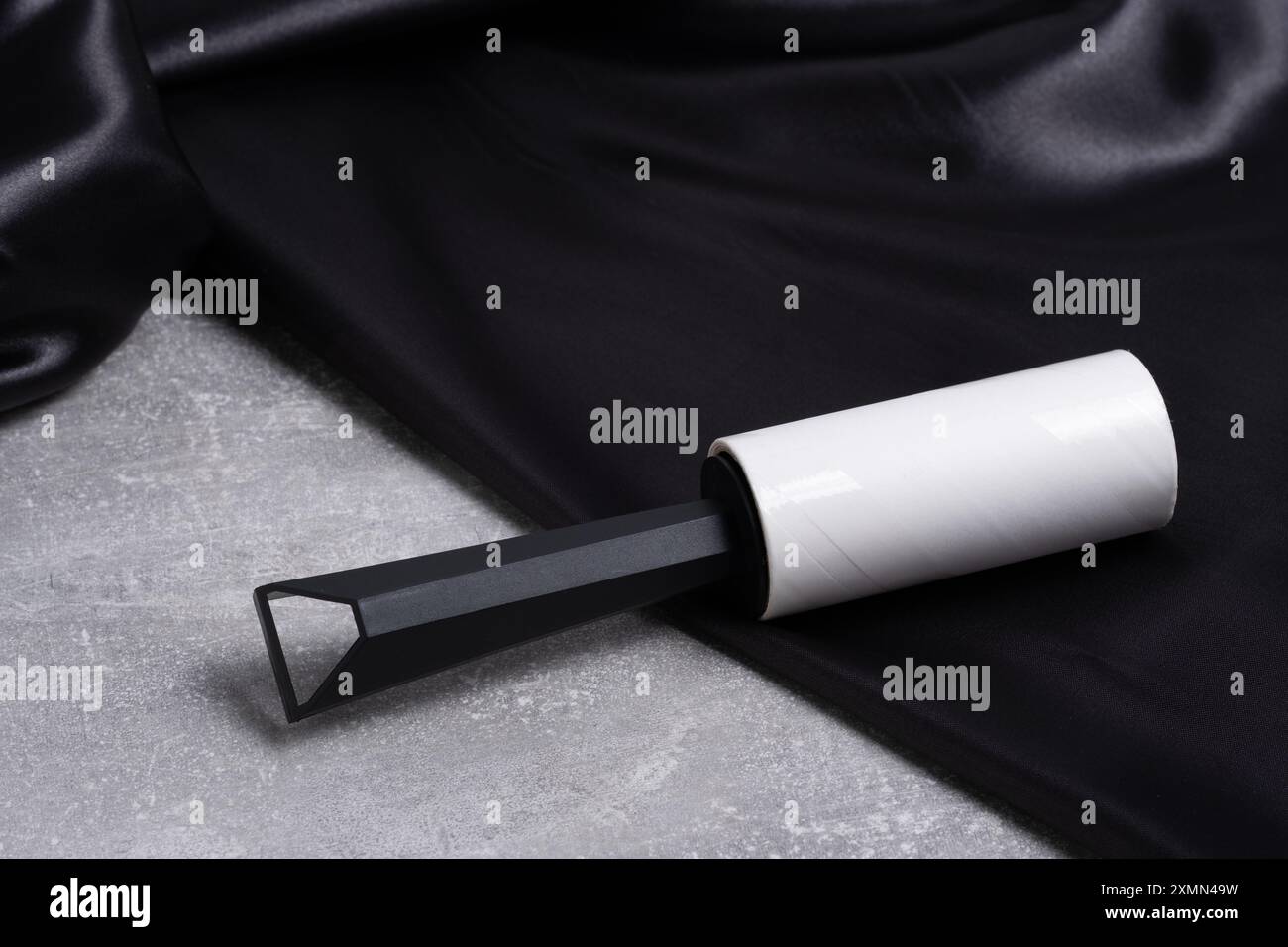 Roller for cleaning clothes on background black satin fabric Stock ...