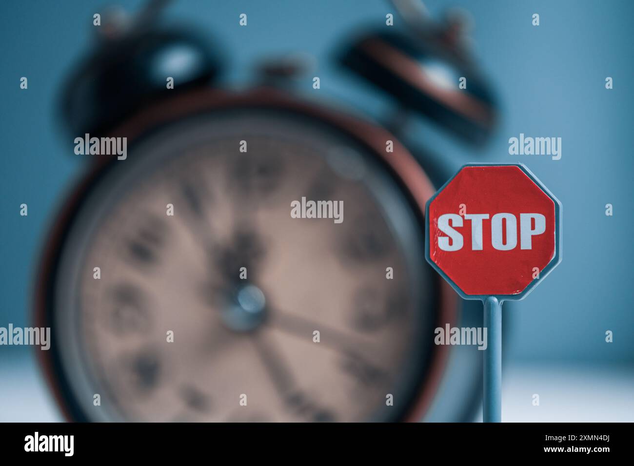 Stop sign and alarm clock on blue background. Stop time concept Stock ...