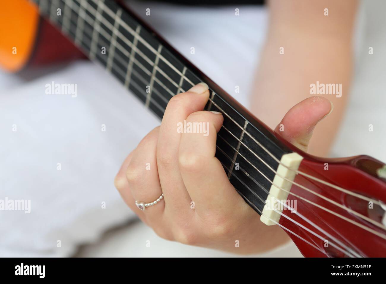 Teenage girl plays acoustic guitar close up of fingers on frets ...