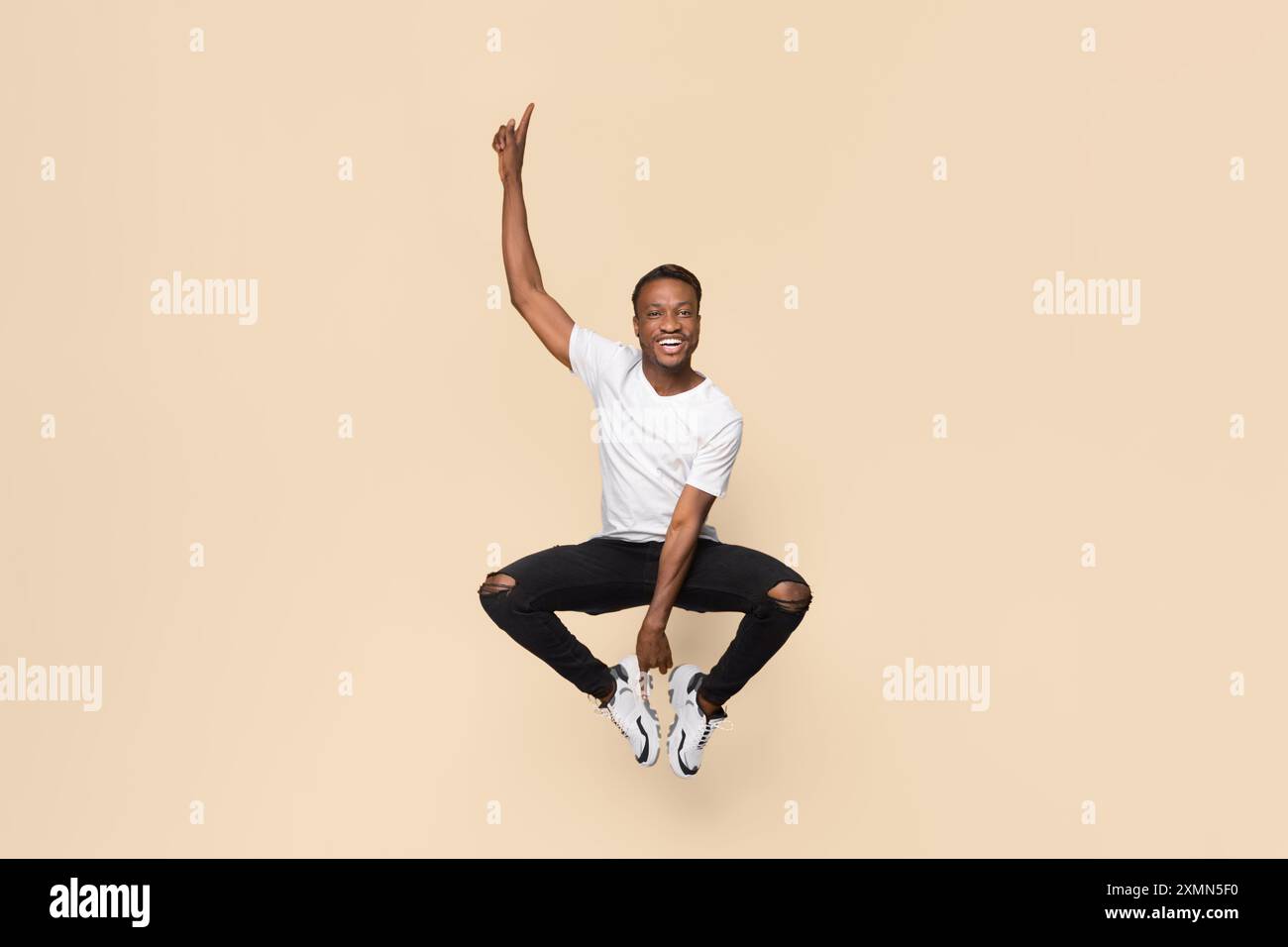 Joyful African American Guy Jumping With Raised Hand, Yellow Background ...