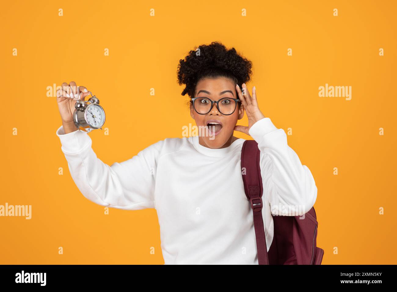 Shocked Student Holding Alarm Clock With Backpack on Yellow Background ...