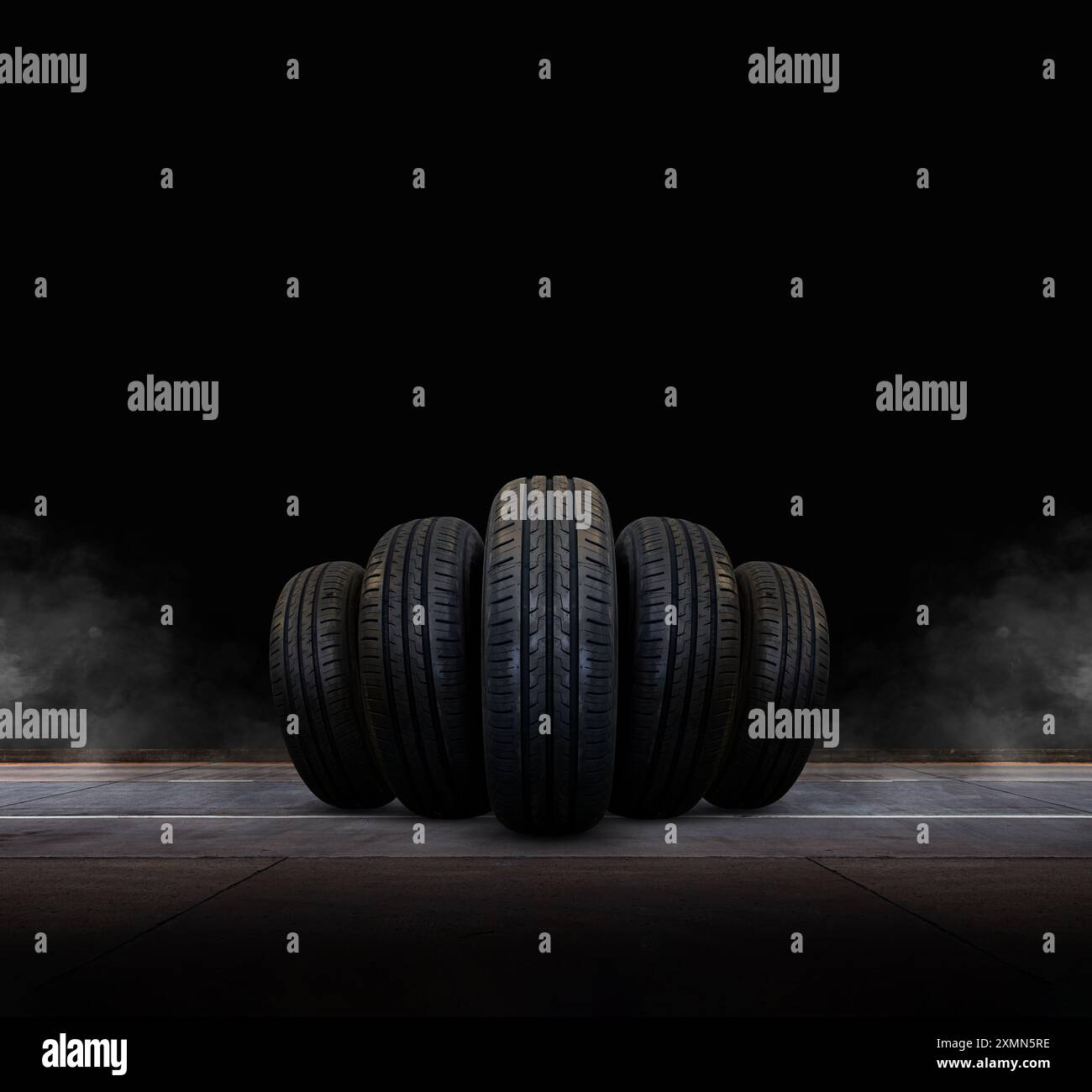 Stack of Tires on an Empty Road with dark Background Stock Photo - Alamy