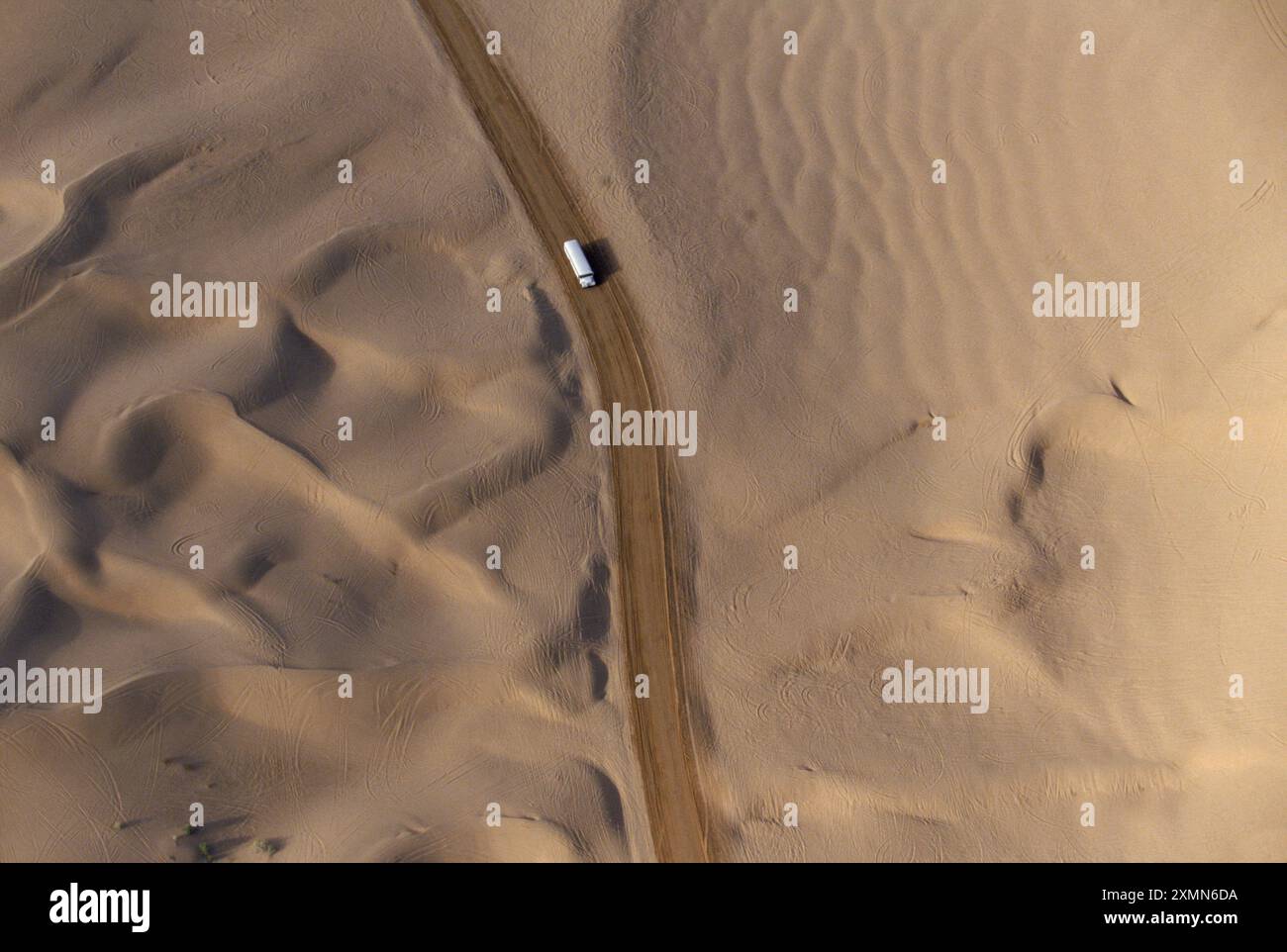 A bus driving through sand dunes Stock Photo - Alamy