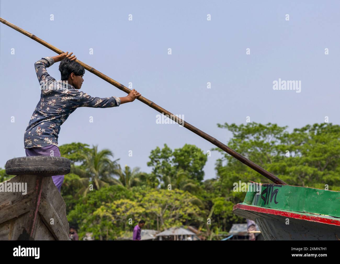 Bangladeshi man pushing a boat with a long stick in Sundarbans, Barisal ...