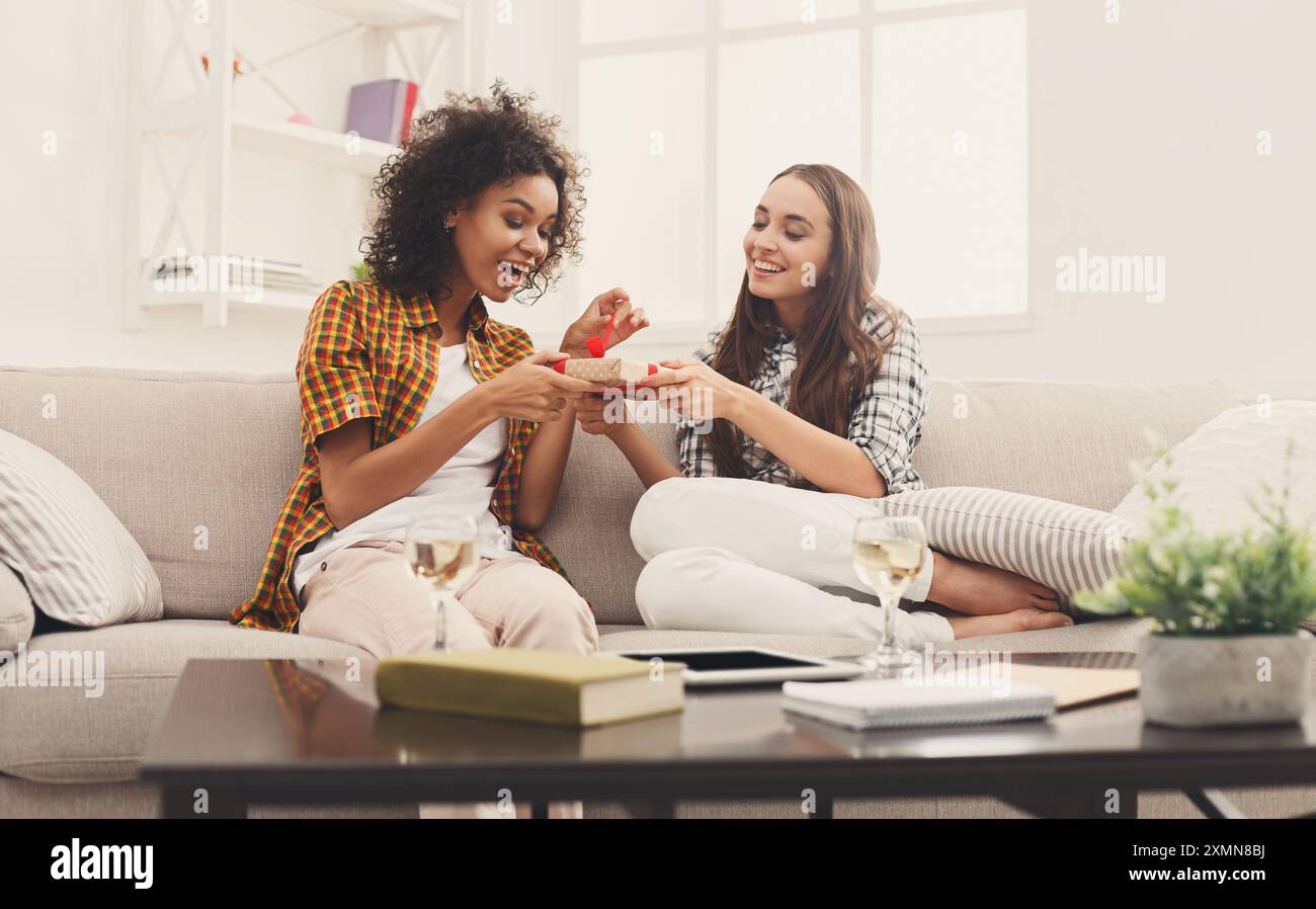 Excited woman getting gift from her girlfiend Stock Photo - Alamy